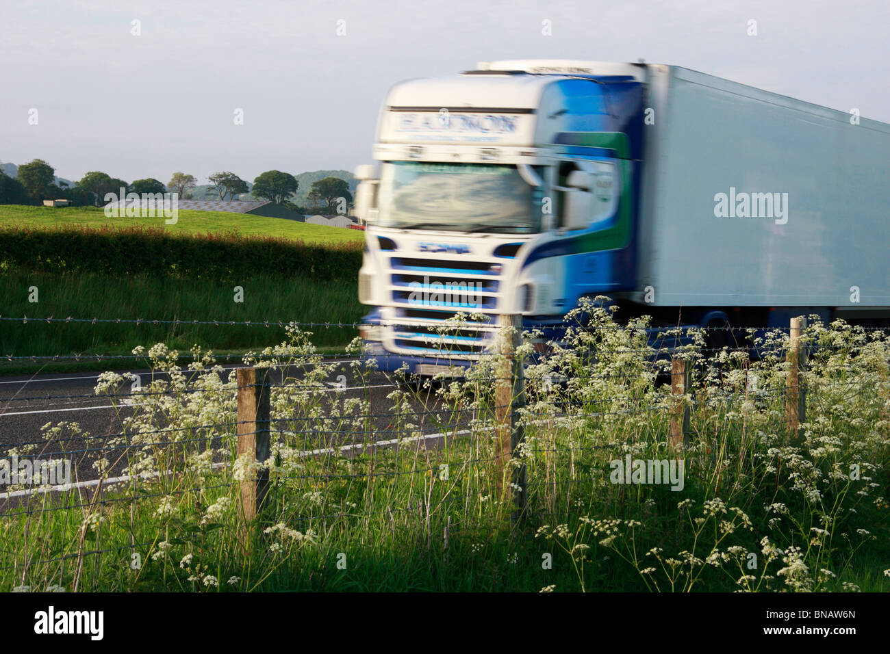 Blurred moving lorry on country road Stock Photo - Alamy