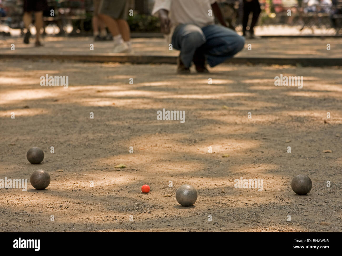 A player gets ready to make the next toss in a petanque game in Bryant ...