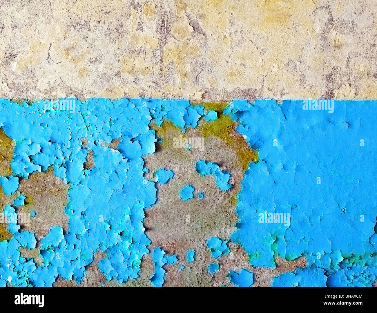 The damaged wall of the ruined building painted in two different colors ...