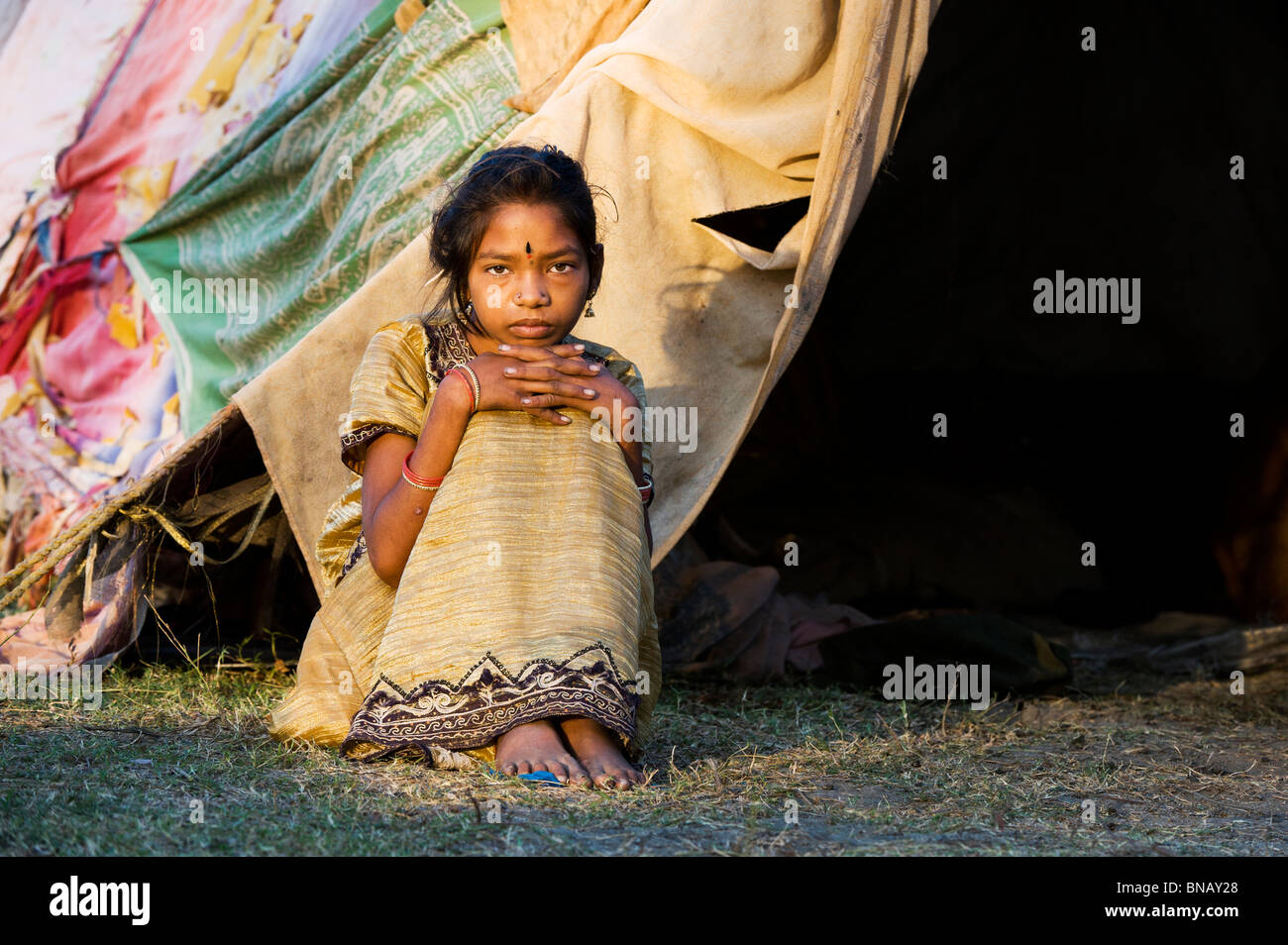 Poor indian girl sitting inside her tent home in the early morning ...