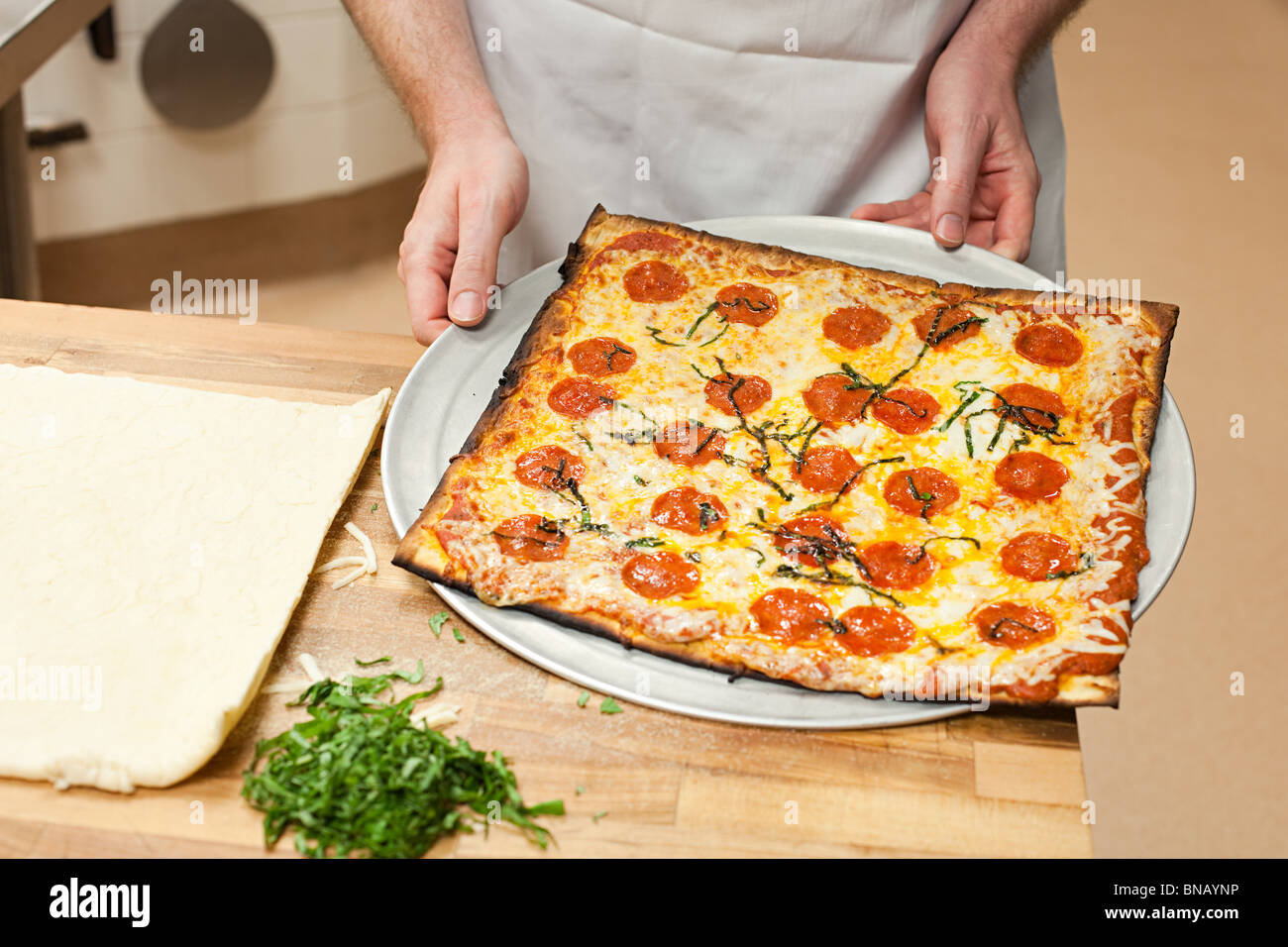Male chef making pizza in commercial kitchen Stock Photo - Alamy