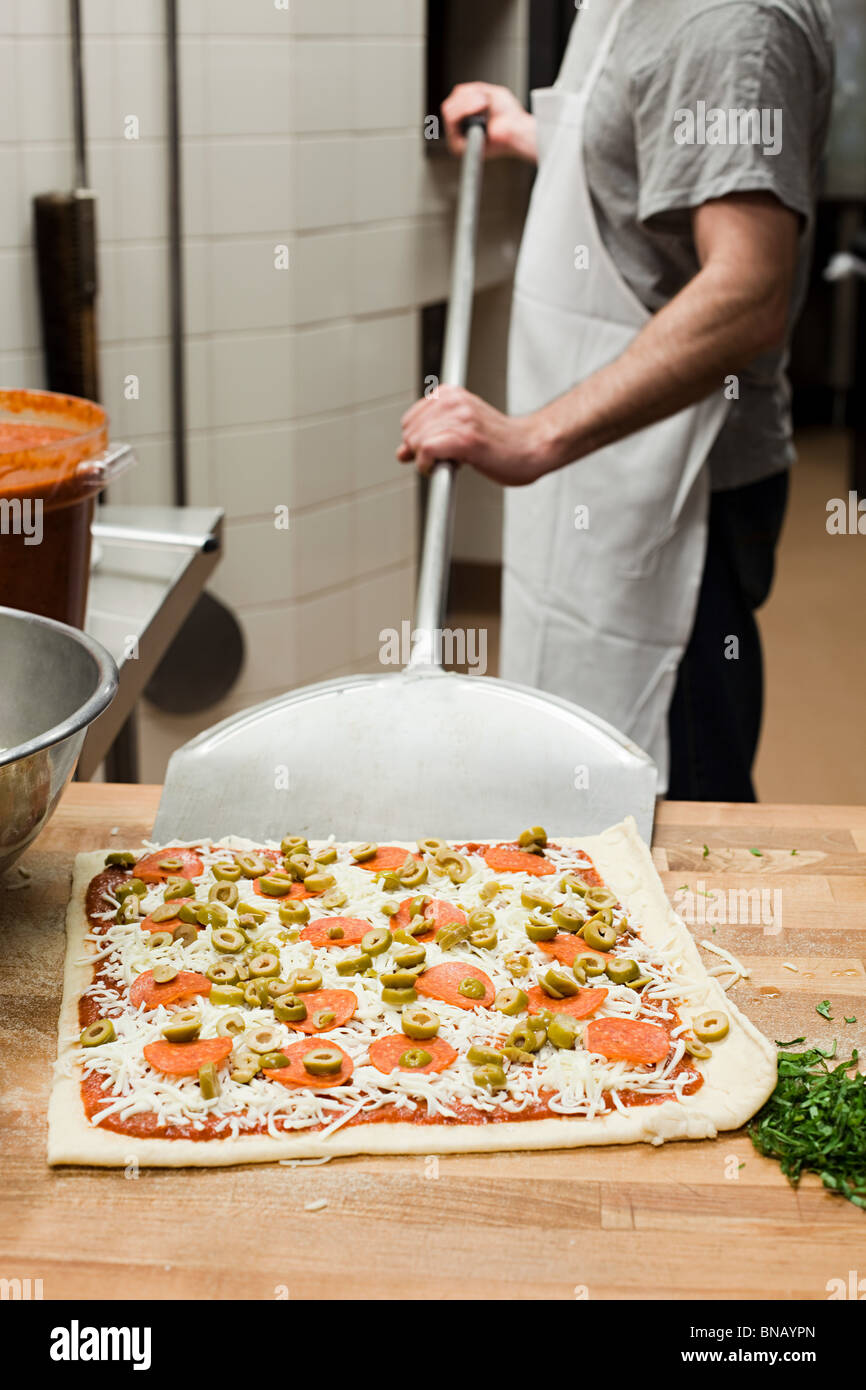 Male chef making pizza in commercial kitchen Stock Photo - Alamy
