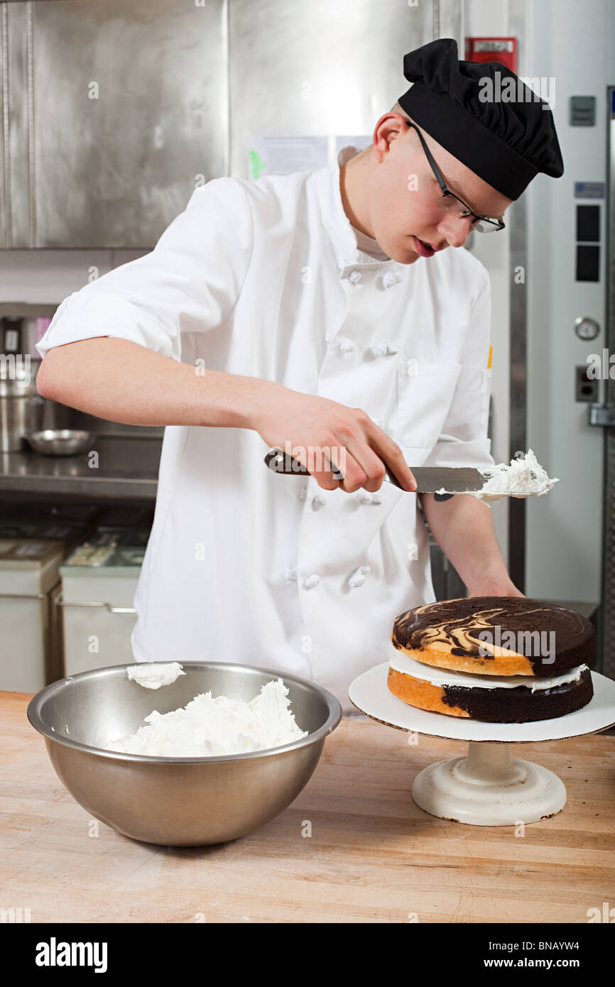 Male chef icing a cake in commercial kitchen Stock Photo - Alamy