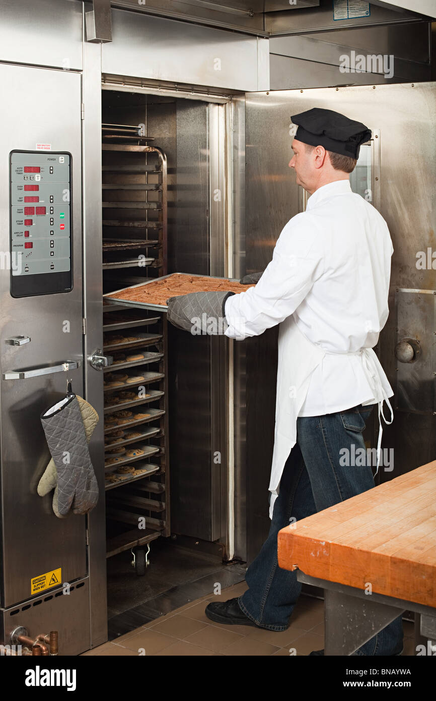 Male chef baking cookies in commercial kitchen Stock Photo - Alamy