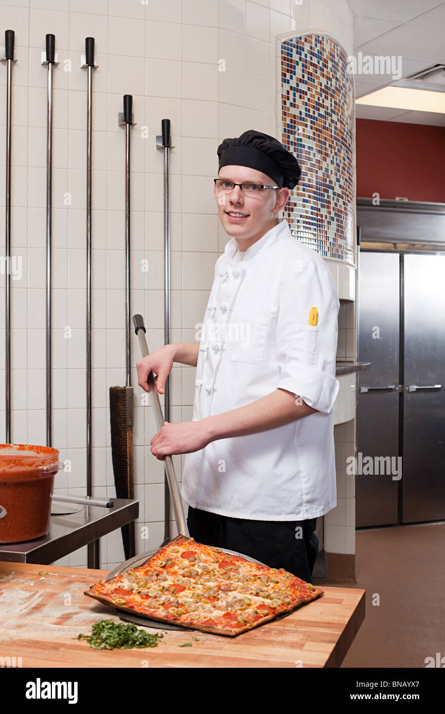 Male chef making pizza in commercial kitchen Stock Photo - Alamy