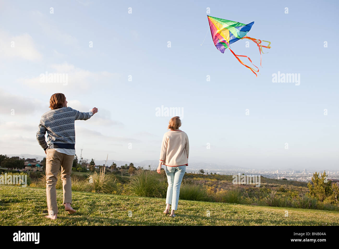 Young couple flying a kite Stock Photo - Alamy