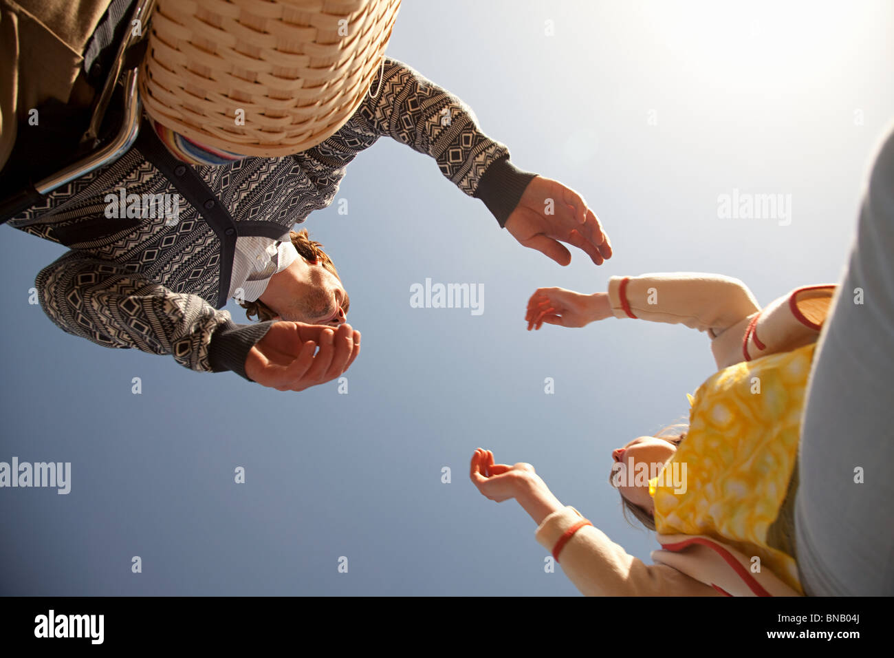 Low angle view of couple reaching for each other Stock Photo - Alamy