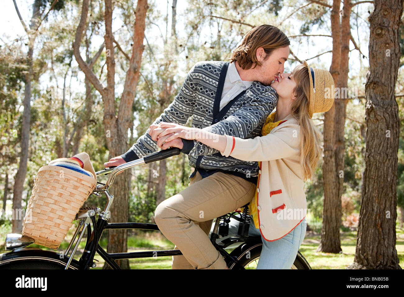 Young couple kissing on bicycle Stock Photo - Alamy