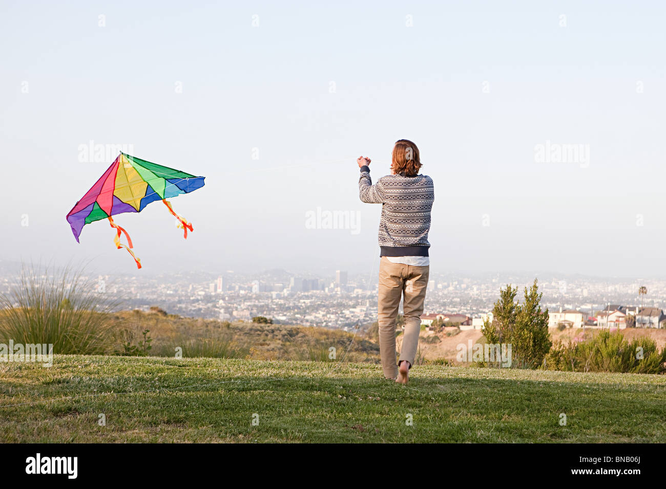Young man flying a kite Stock Photo - Alamy
