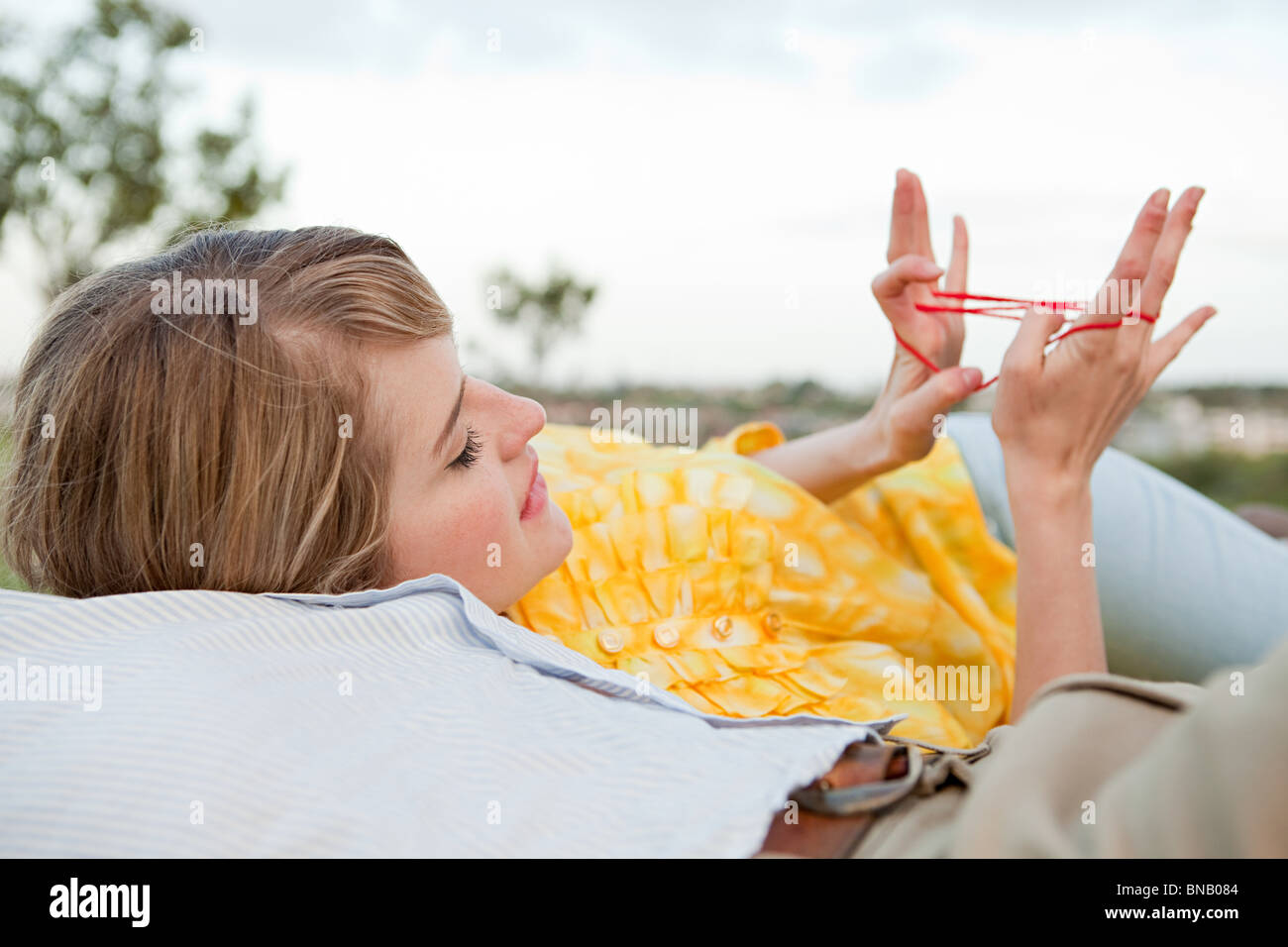 Young couple outdoors, woman playing with string Stock Photo - Alamy