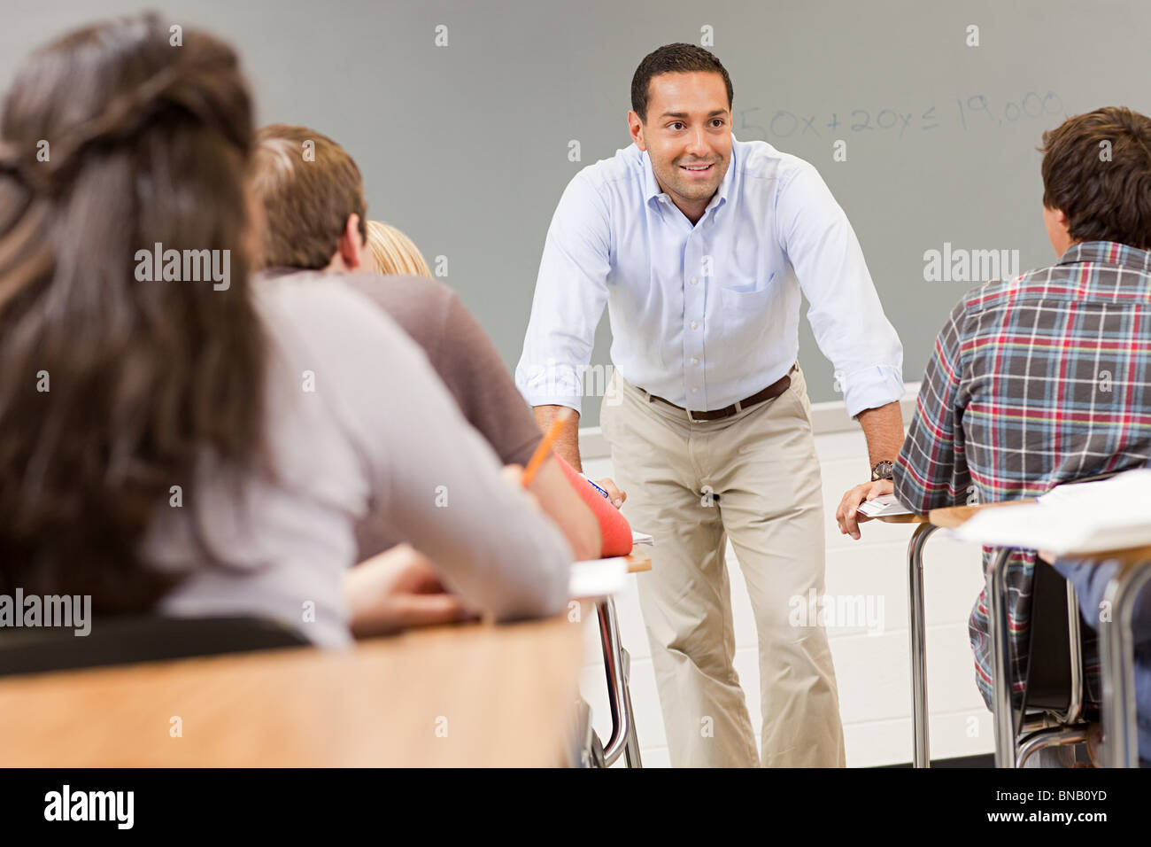 Male high school teacher and students in classroom Stock Photo - Alamy