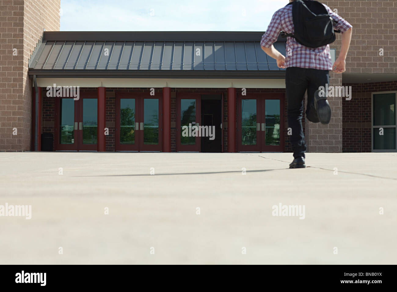 Male high school student running toward school Stock Photo - Alamy