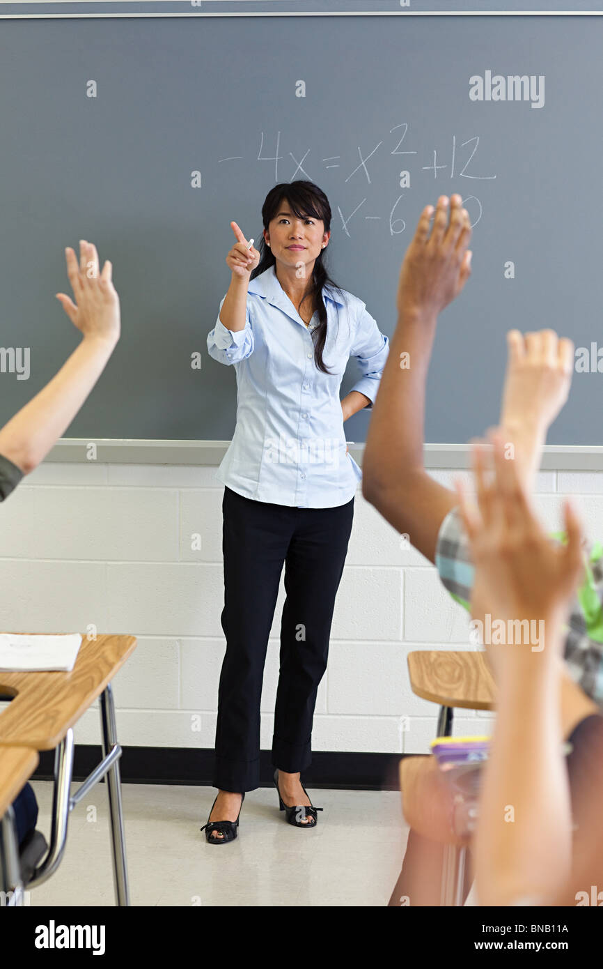 High school students with arms raised in classroom Stock Photo - Alamy