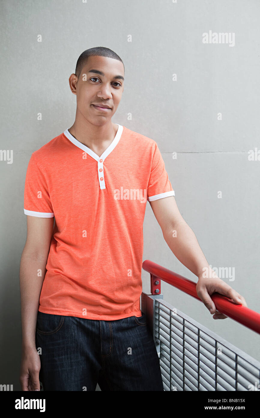 Young man by railing Stock Photo - Alamy