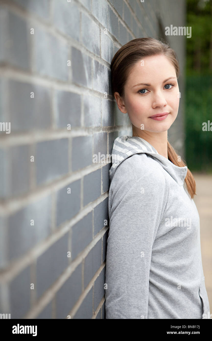 Young woman by wall Stock Photo - Alamy