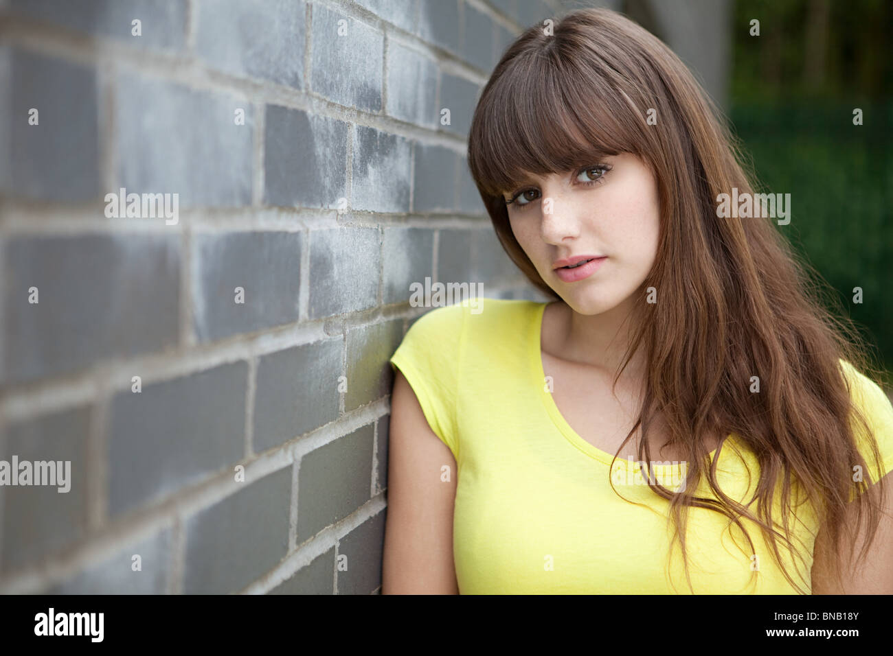 Young woman by a wall Stock Photo - Alamy
