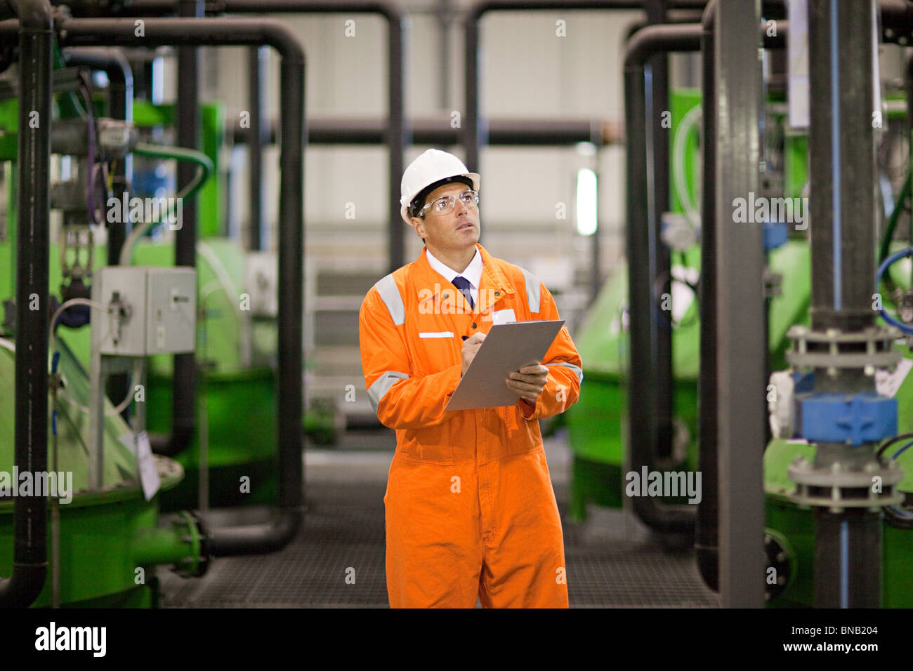 Engineer inspecting machinery in factory Stock Photo - Alamy