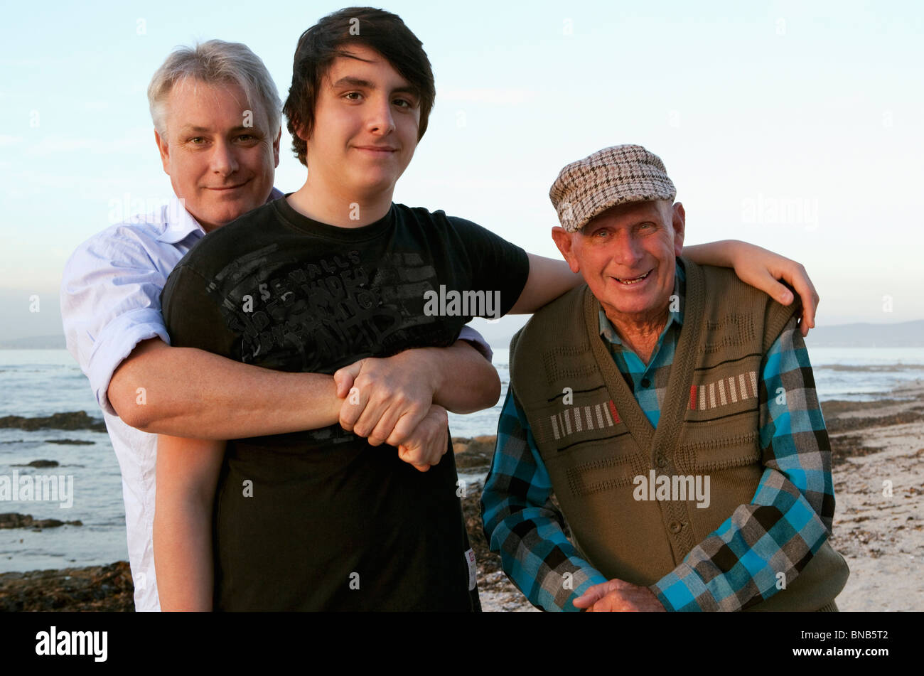 Three generations of men on beach Stock Photo - Alamy