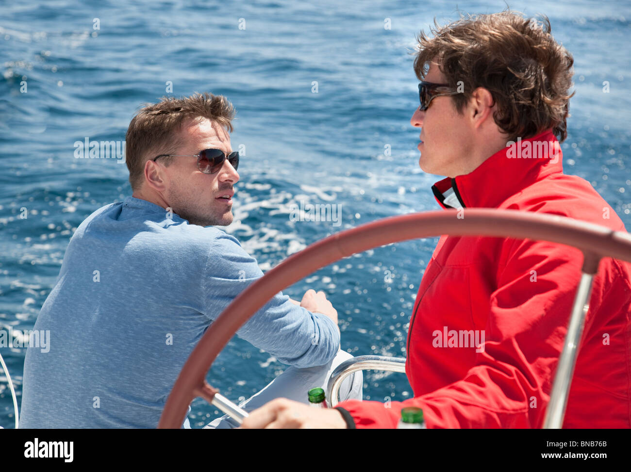 Men talking on yacht Stock Photo - Alamy