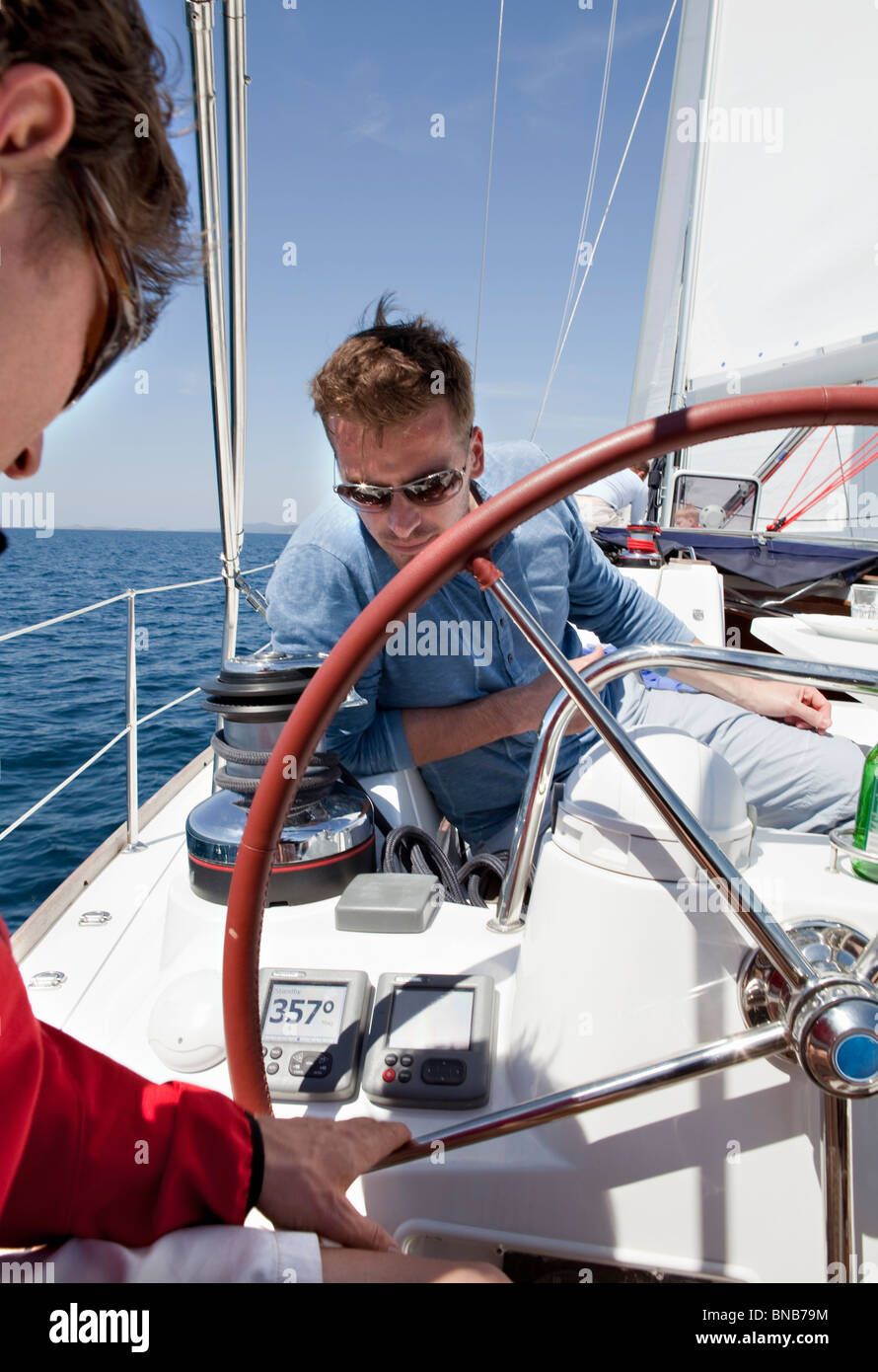 Men navigating yacht Stock Photo - Alamy