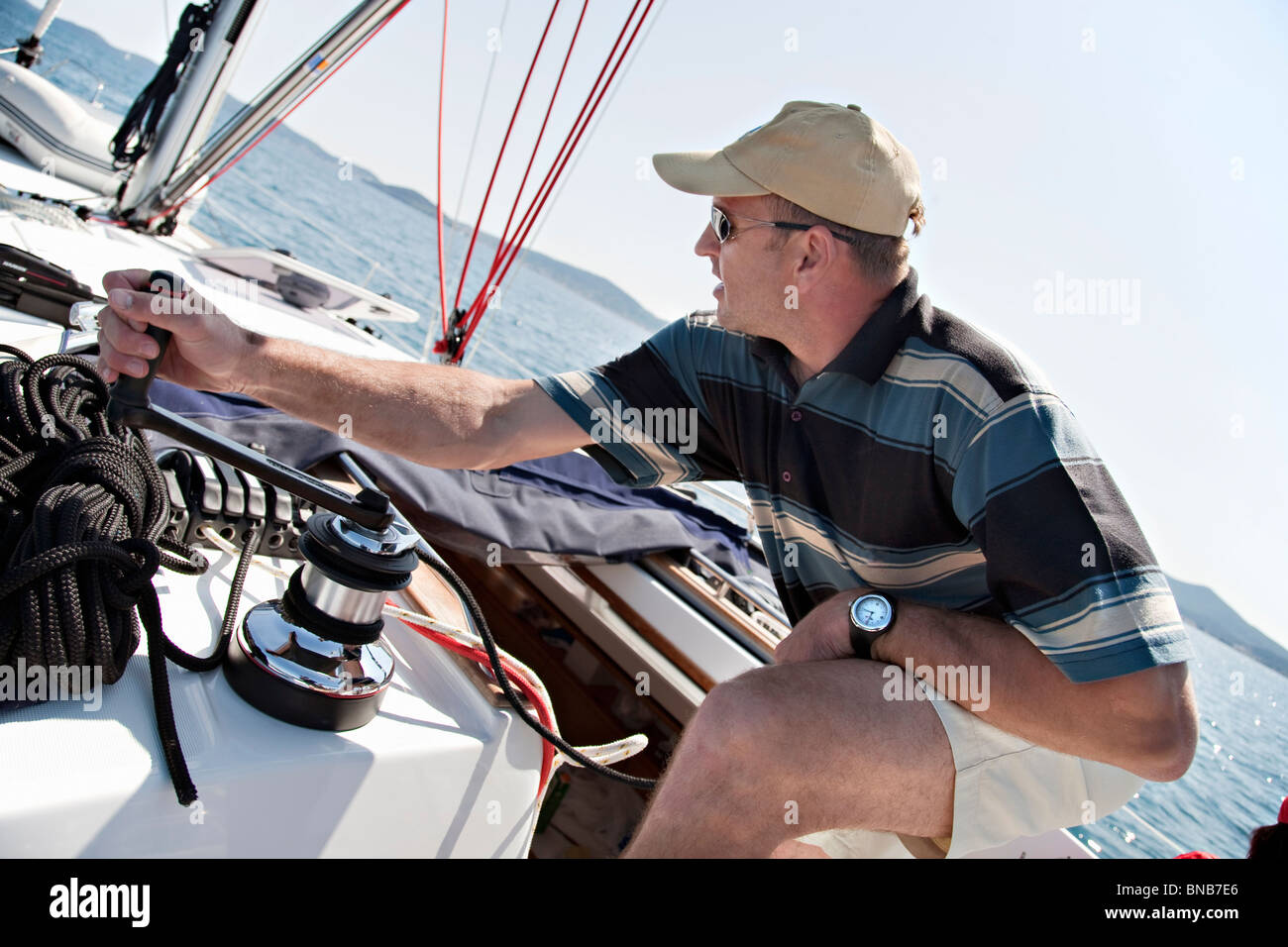 Man hoisting sail on yacht Stock Photo - Alamy