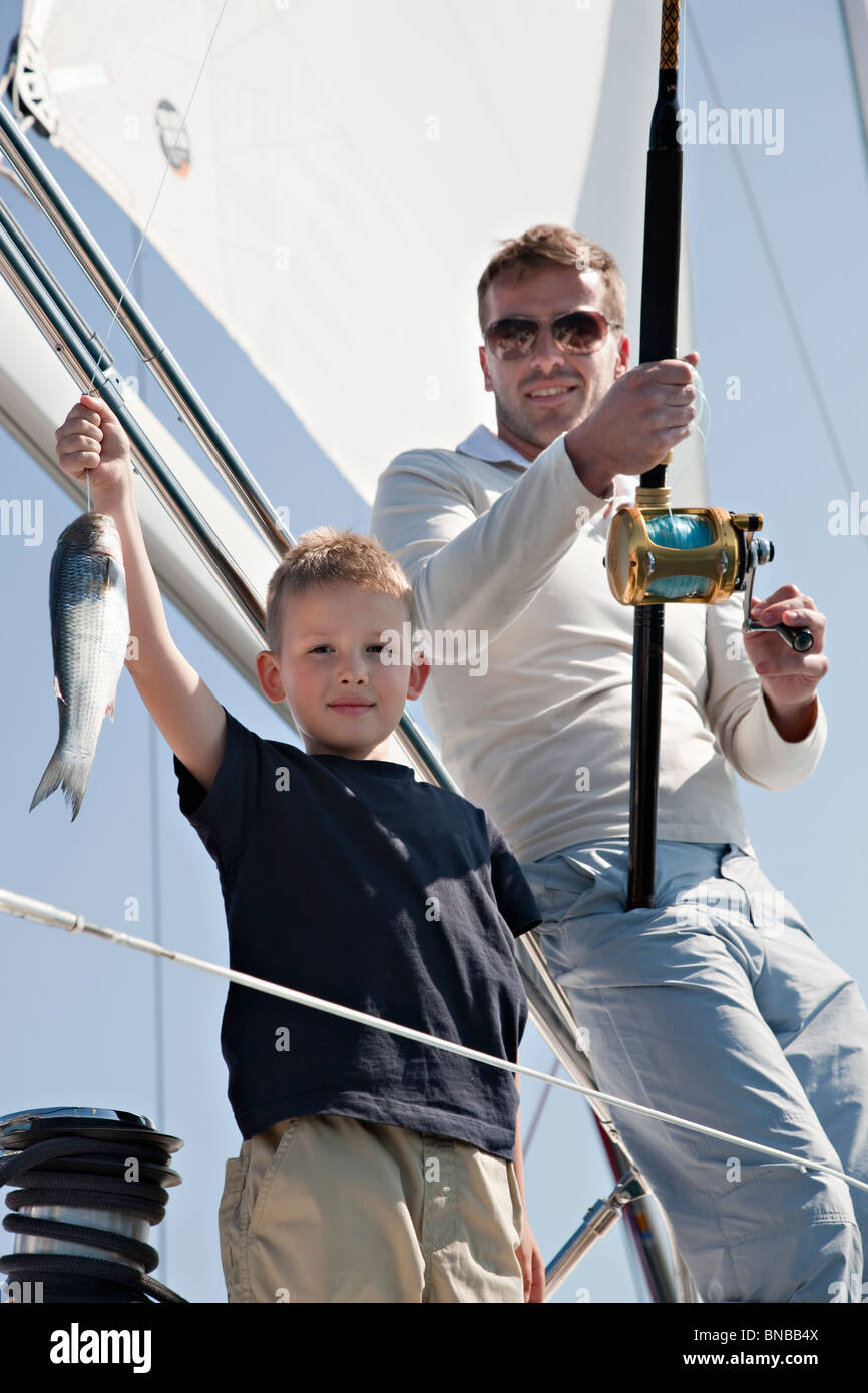 Father and son fishing on yacht Stock Photo - Alamy