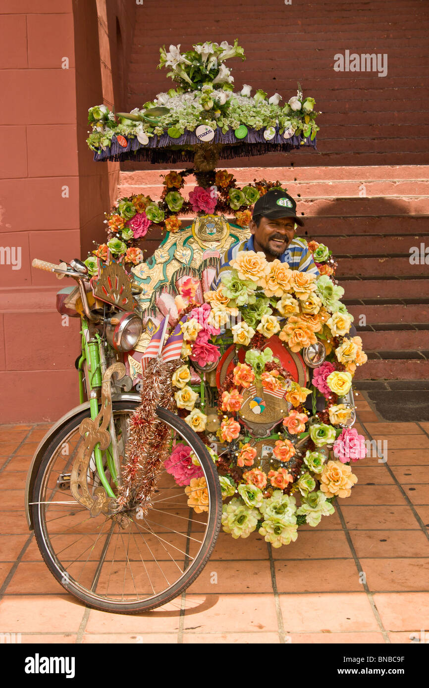 Rickshaw in Melaka, decorated with plastic flowers, and his smiling ...