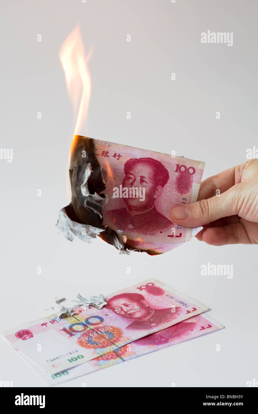 Burning money. Chinese Hundred Yuan bills on fire Stock Photo - Alamy