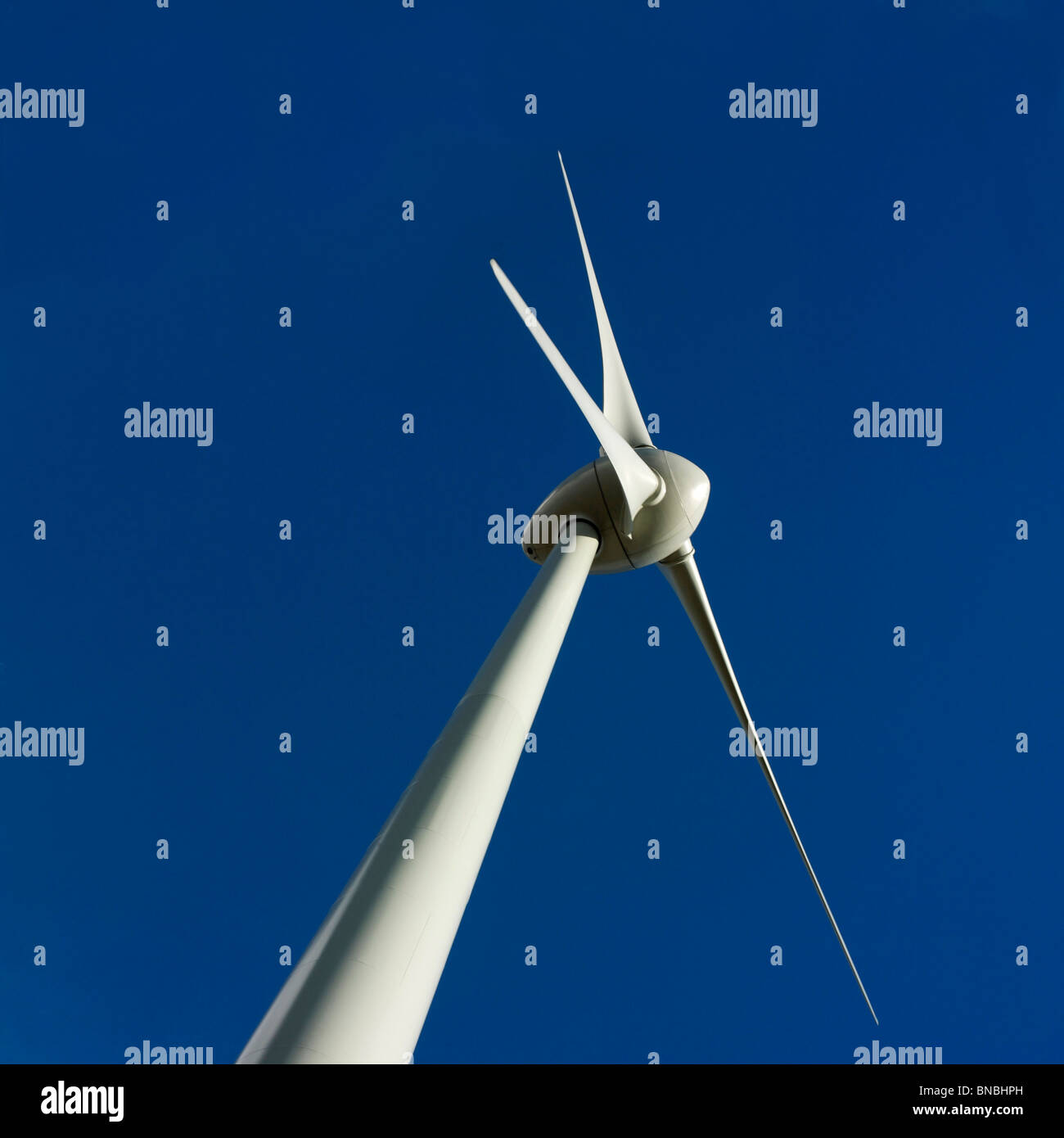 Capturing the height of a wind turbine against a clear blue sky with ...