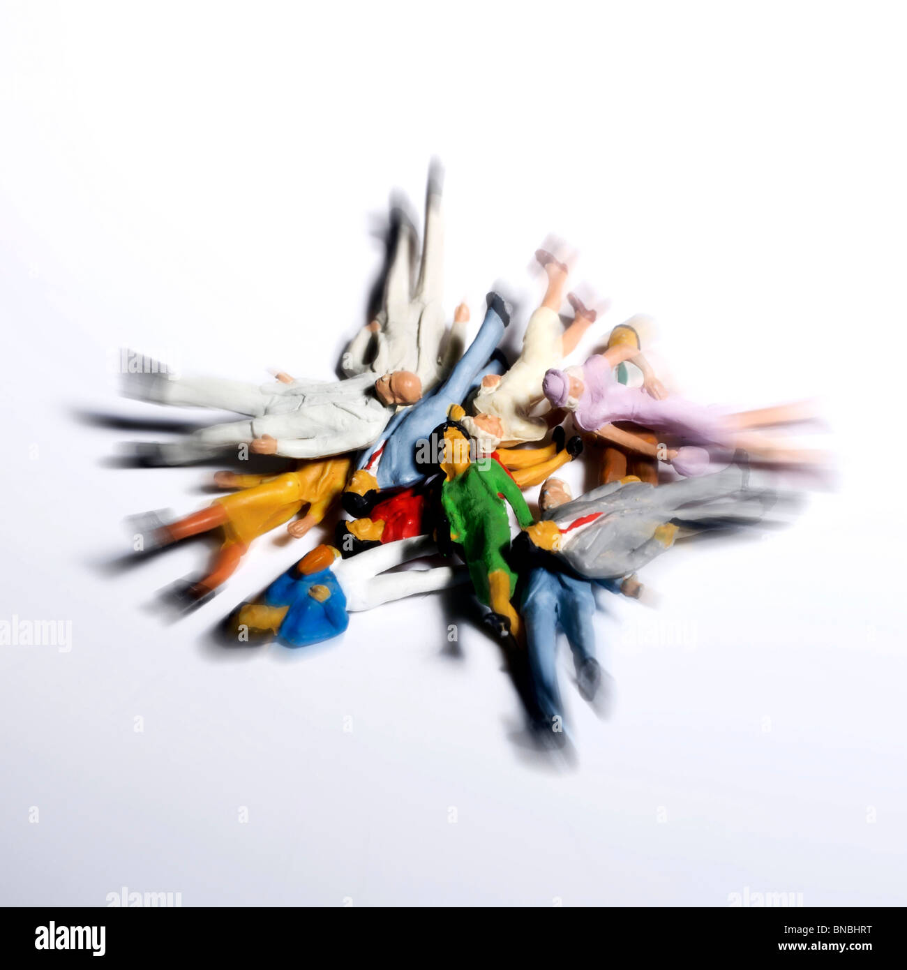 Colorful miniature figures scattered on a white surface creating an ...