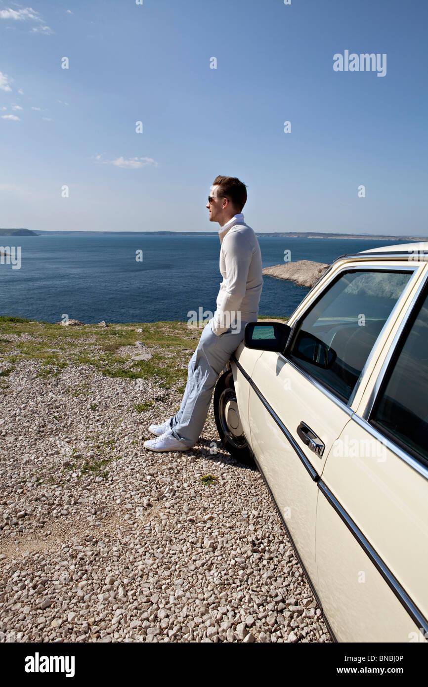 Man with oldtimer overlooking sea Stock Photo - Alamy