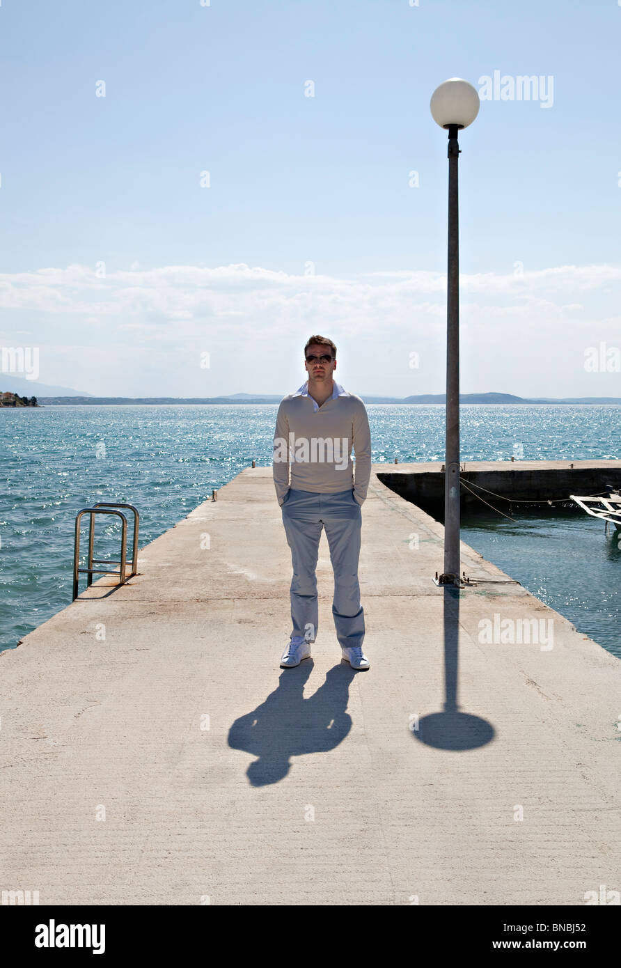 Man standing on pier by sea Stock Photo - Alamy