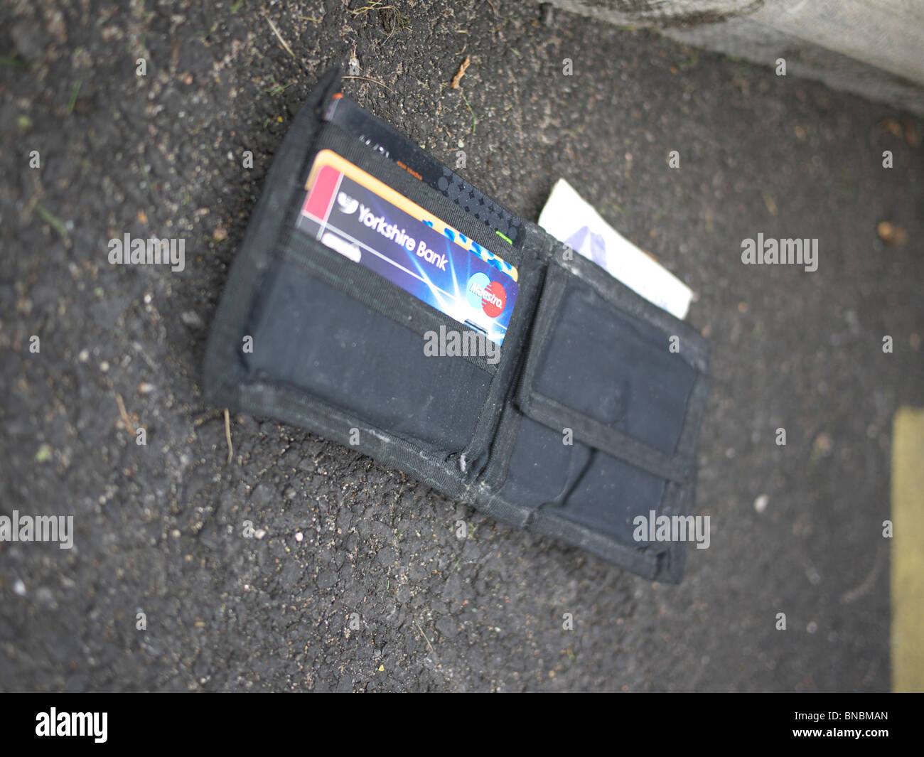 A wallet dropped, lost, on a road Stock Photo - Alamy