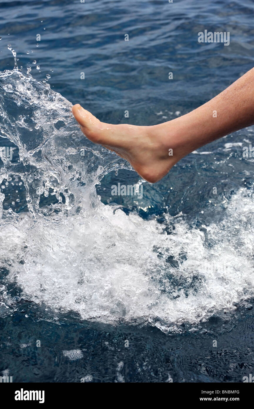 Foot of young man in water – splash Stock Photo - Alamy