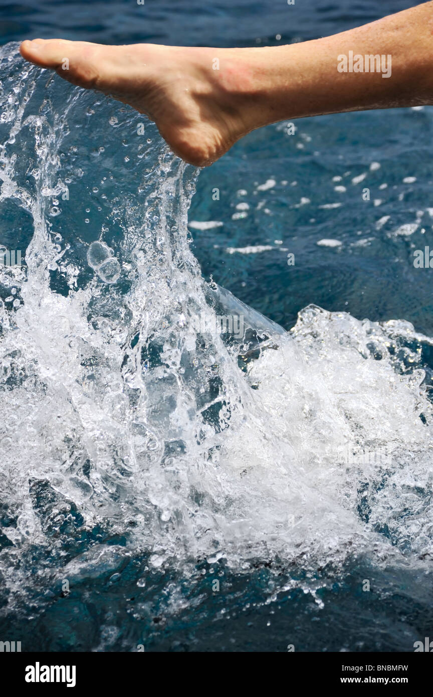 Foot of young man in water – splash Stock Photo - Alamy