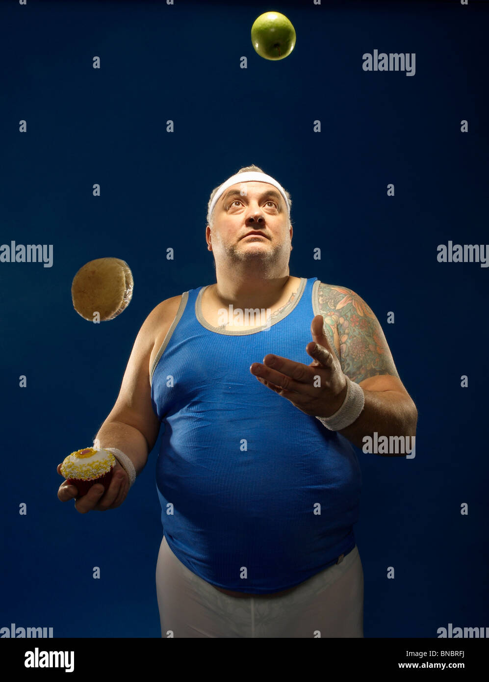 Large sportsman juggling food Stock Photo - Alamy