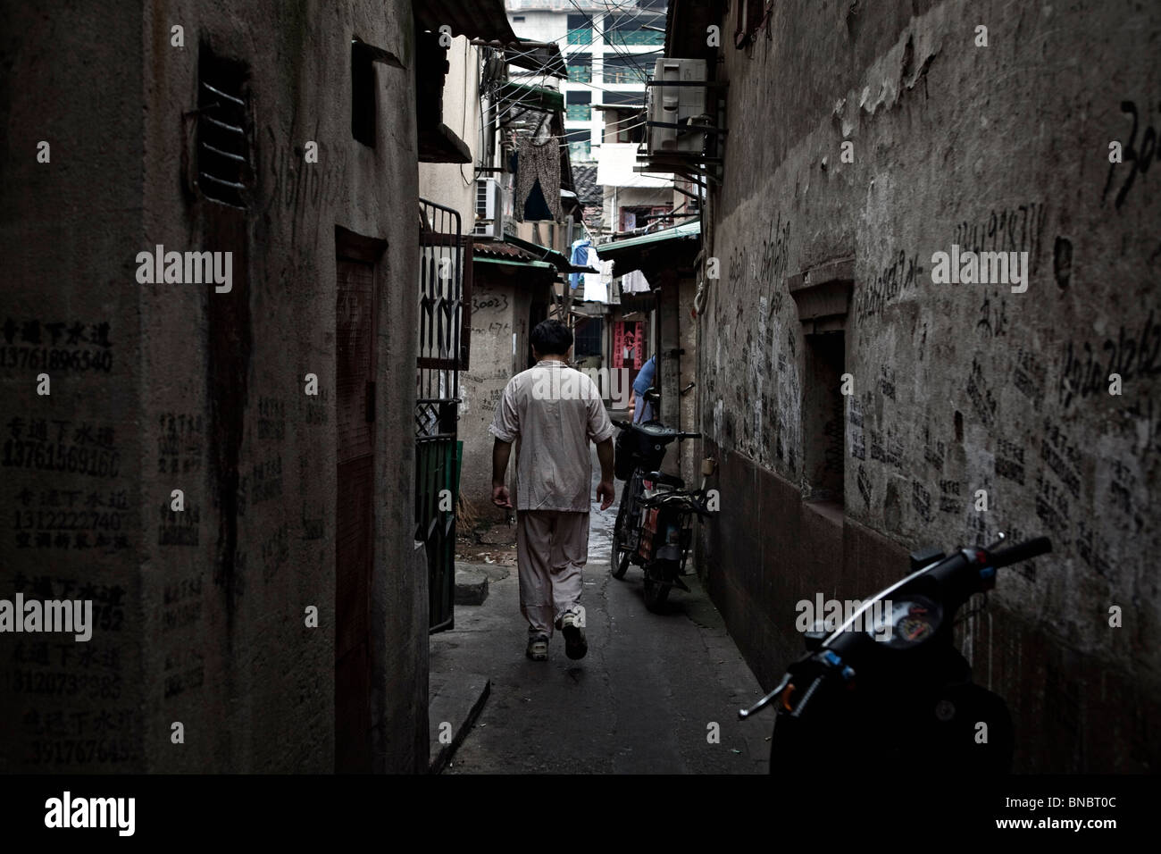 A resident walks down an alley in an old neighbourhood in the Puxi area ...