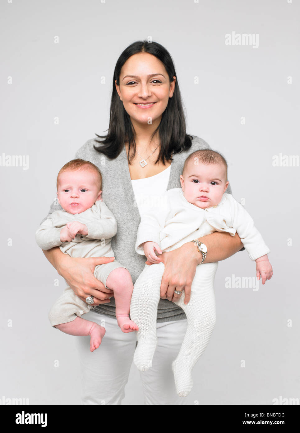 Mother holding two babies Stock Photo - Alamy