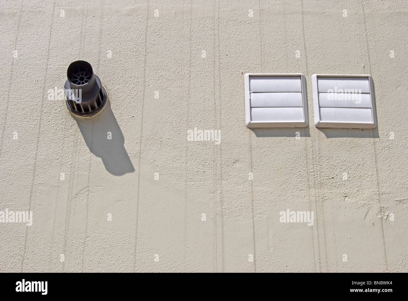 two air vents and a domestic gas flue in an exterior wall of a house in ...