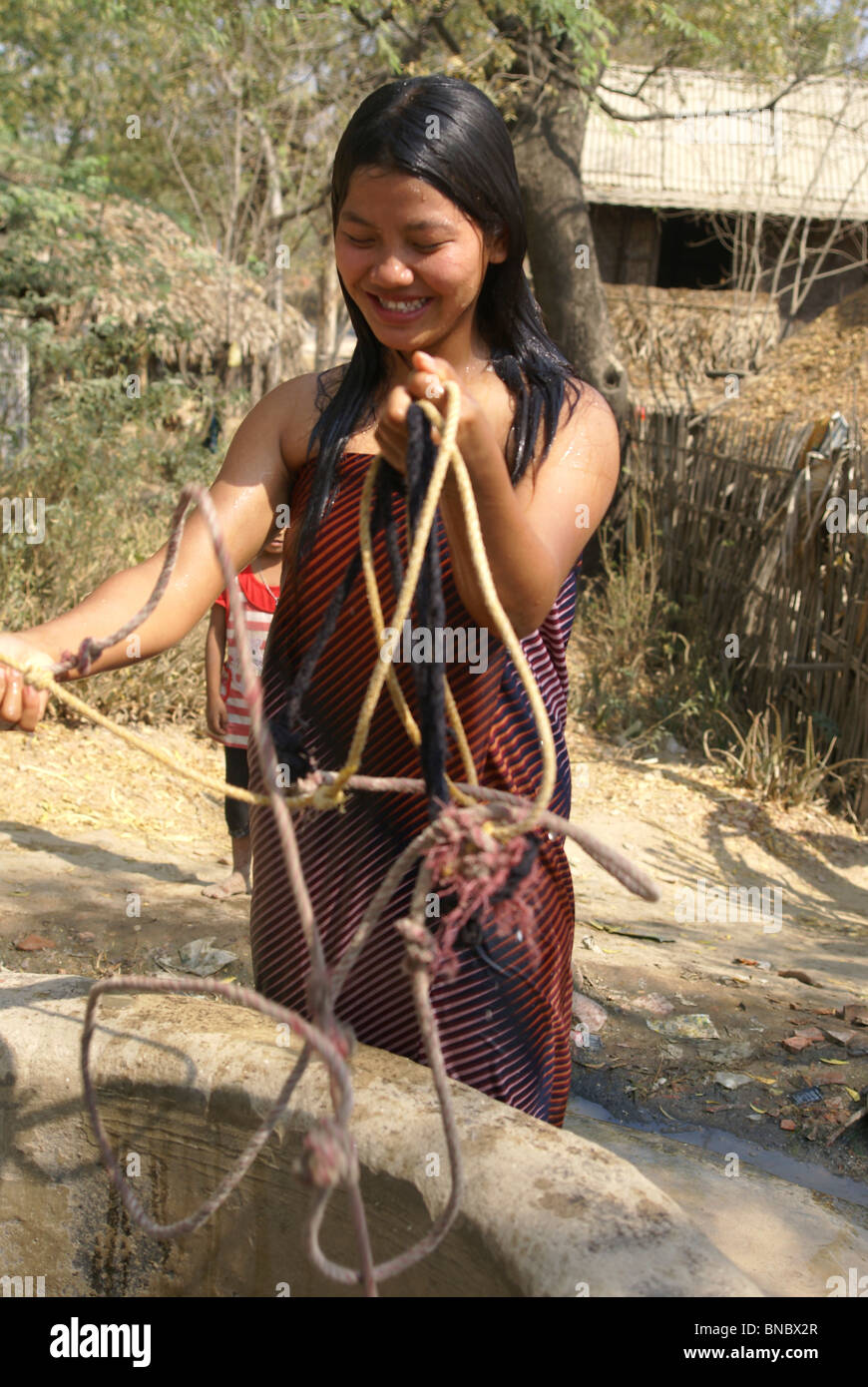 Myanmar, Pakokku, young woman draws water from a well on the banks of ...
