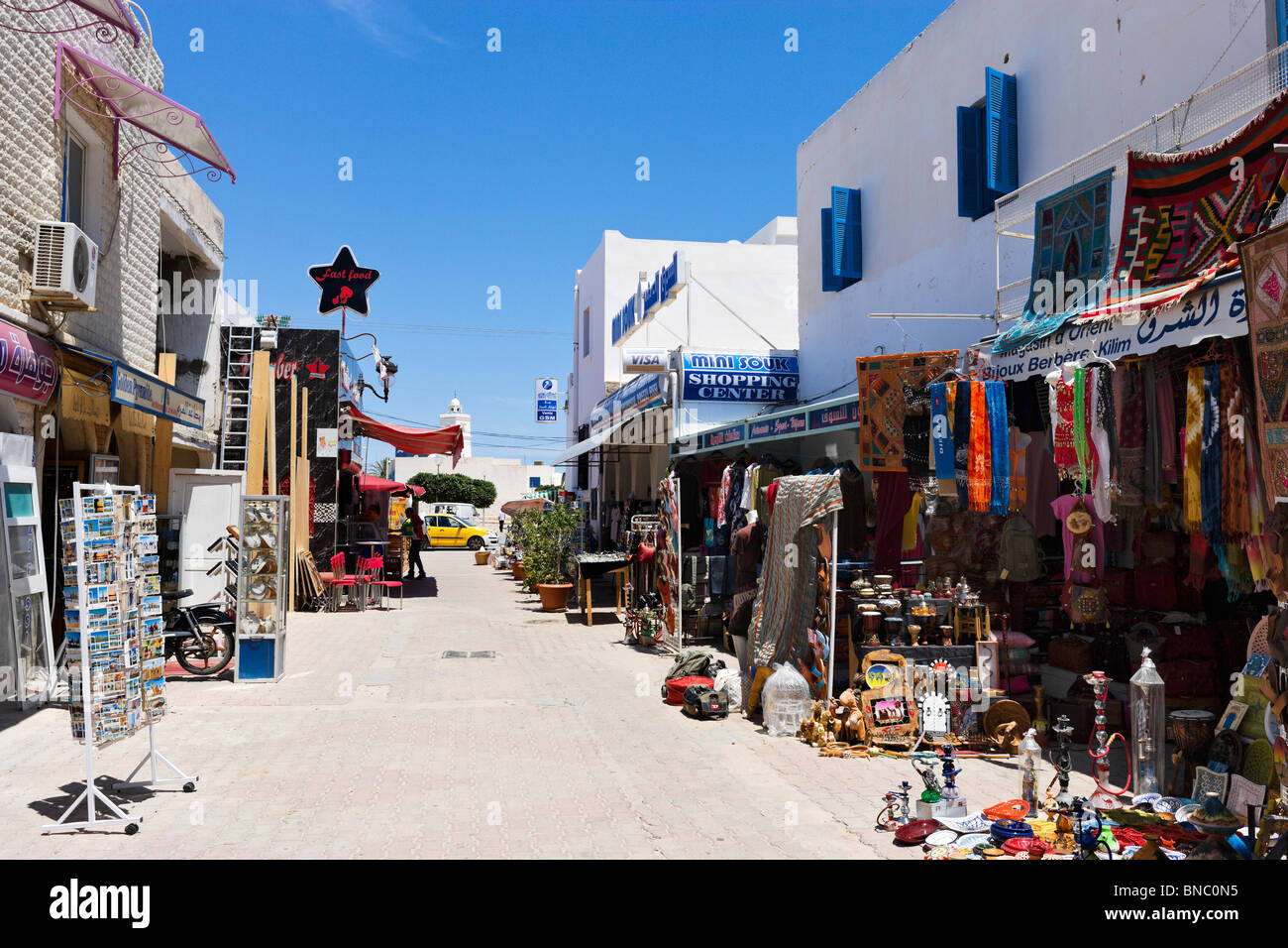 Shops in the centre of Midoun with a mosque in the background, Djerba ...