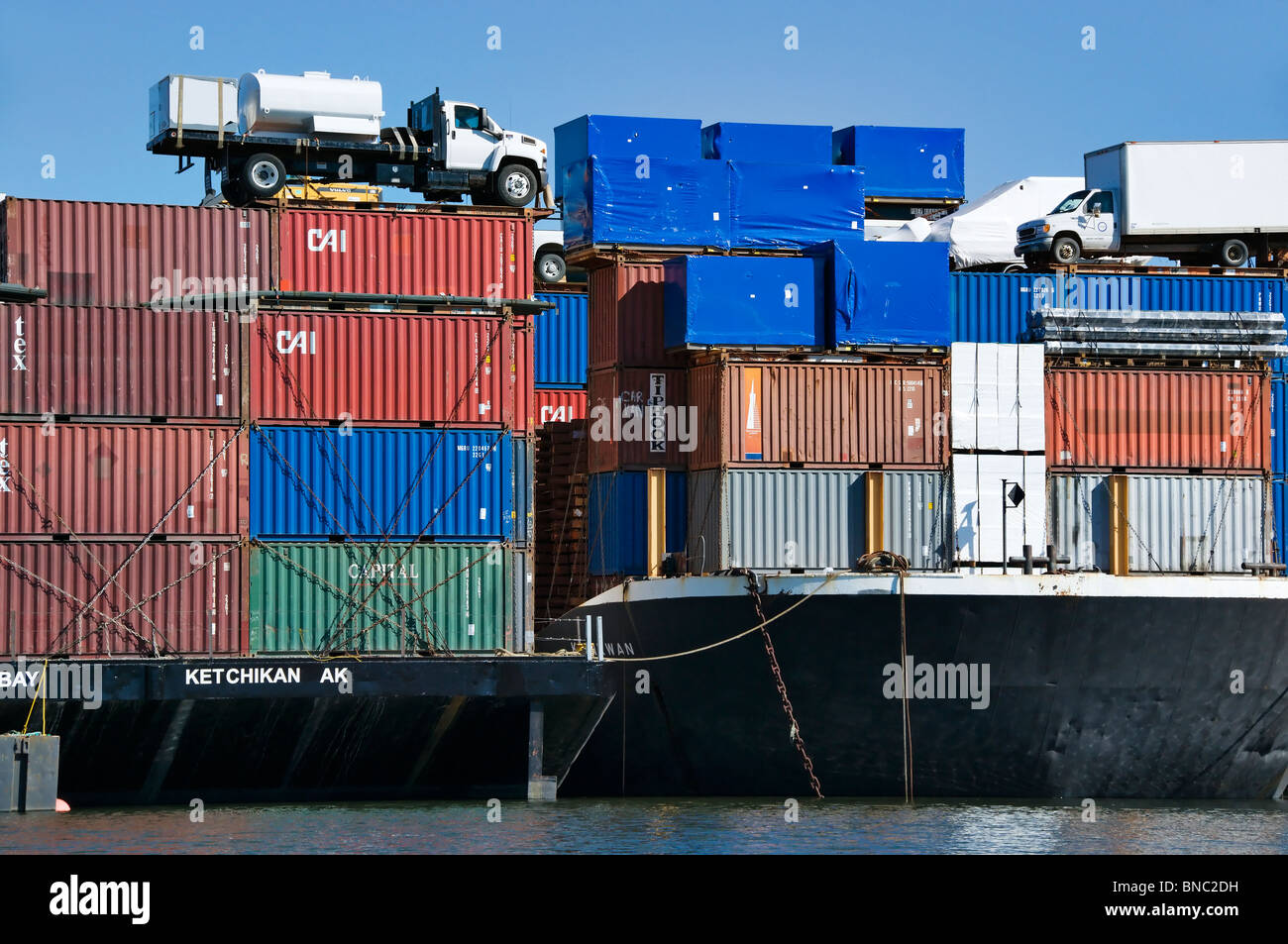 A container ship is loaded with containers and vehicles for transport ...