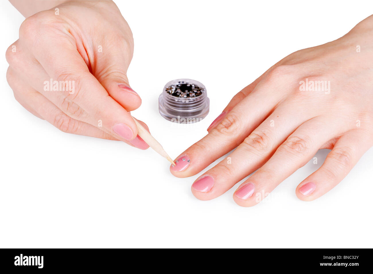 Gluing crystals on the nails - close-up on white Stock Photo - Alamy
