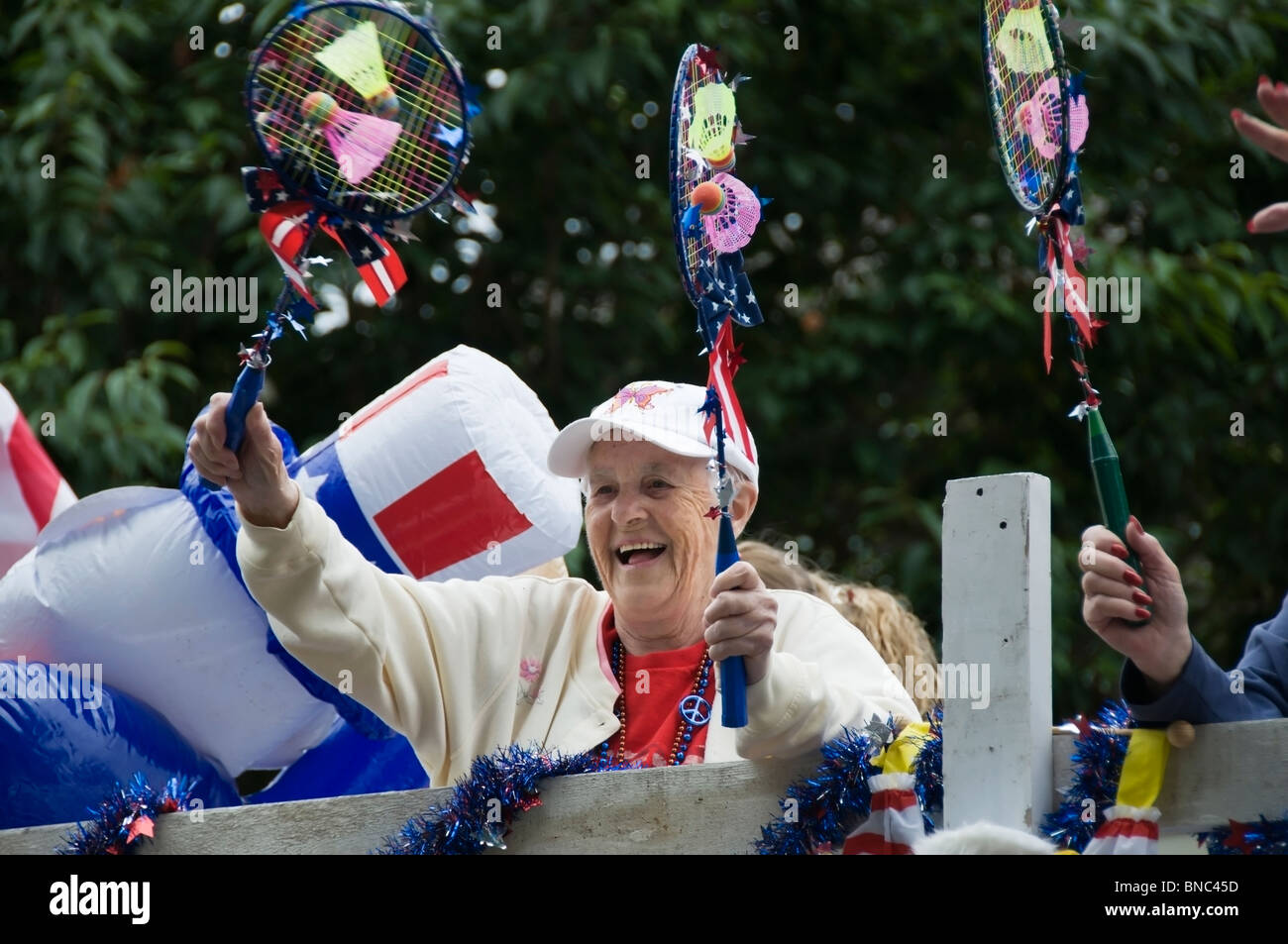 A fun senior citizen rides in a parade float during the 4th of July ...