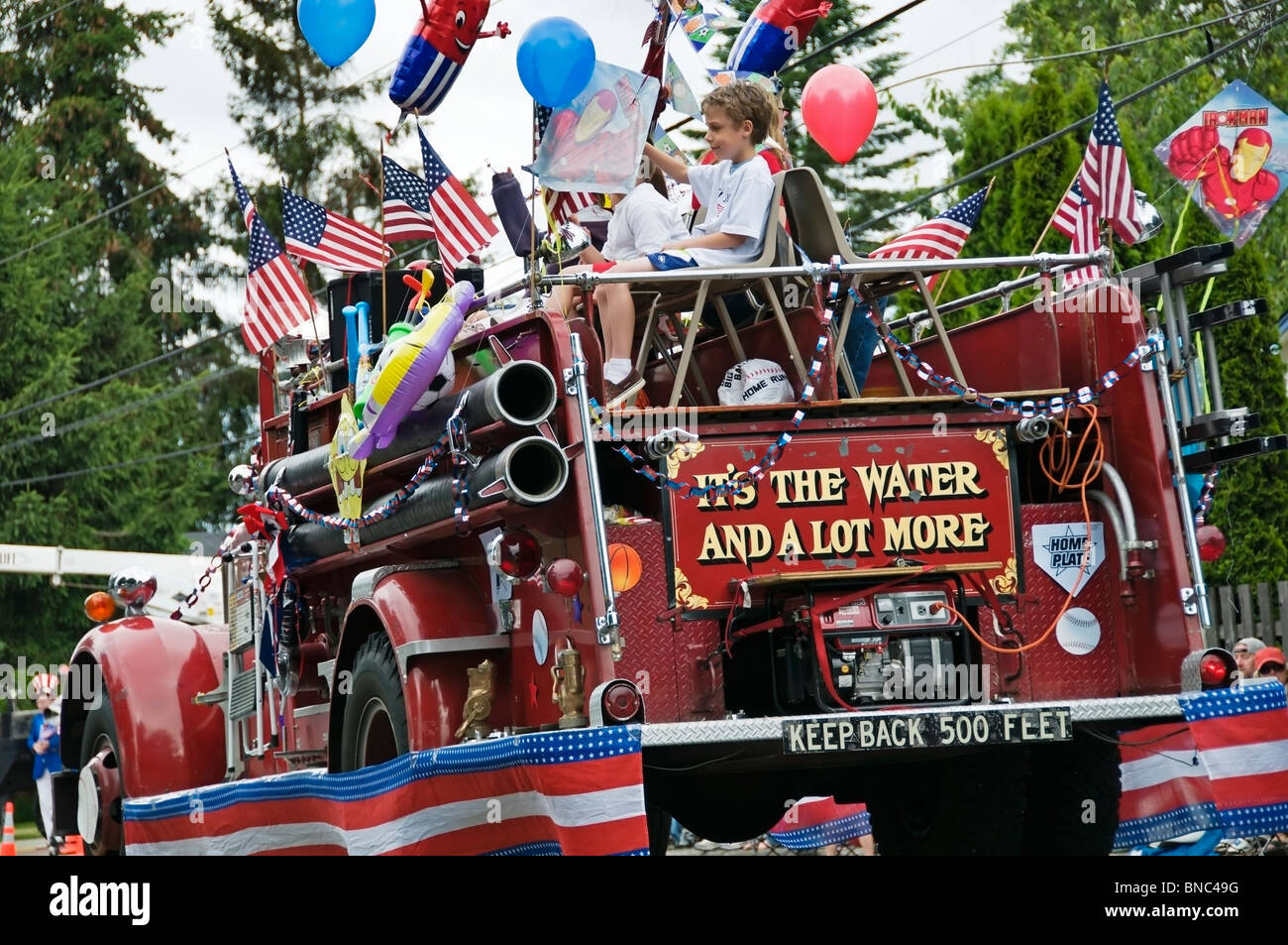 Back view of a festive fire truck as it moves along the parade route in ...
