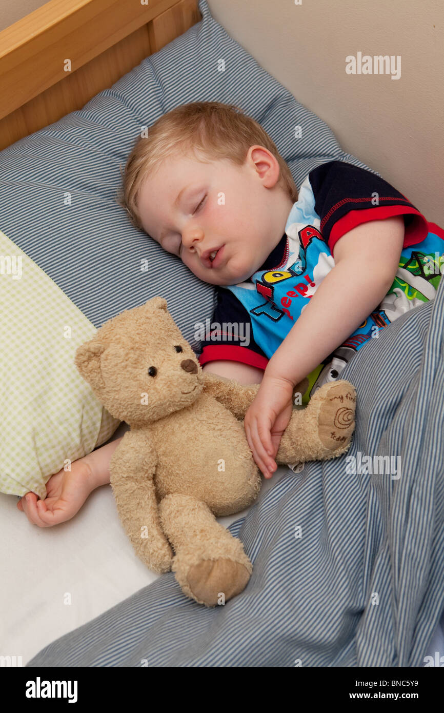 Young boy asleep in his bed, cuddling his teddy bear Stock Photo - Alamy