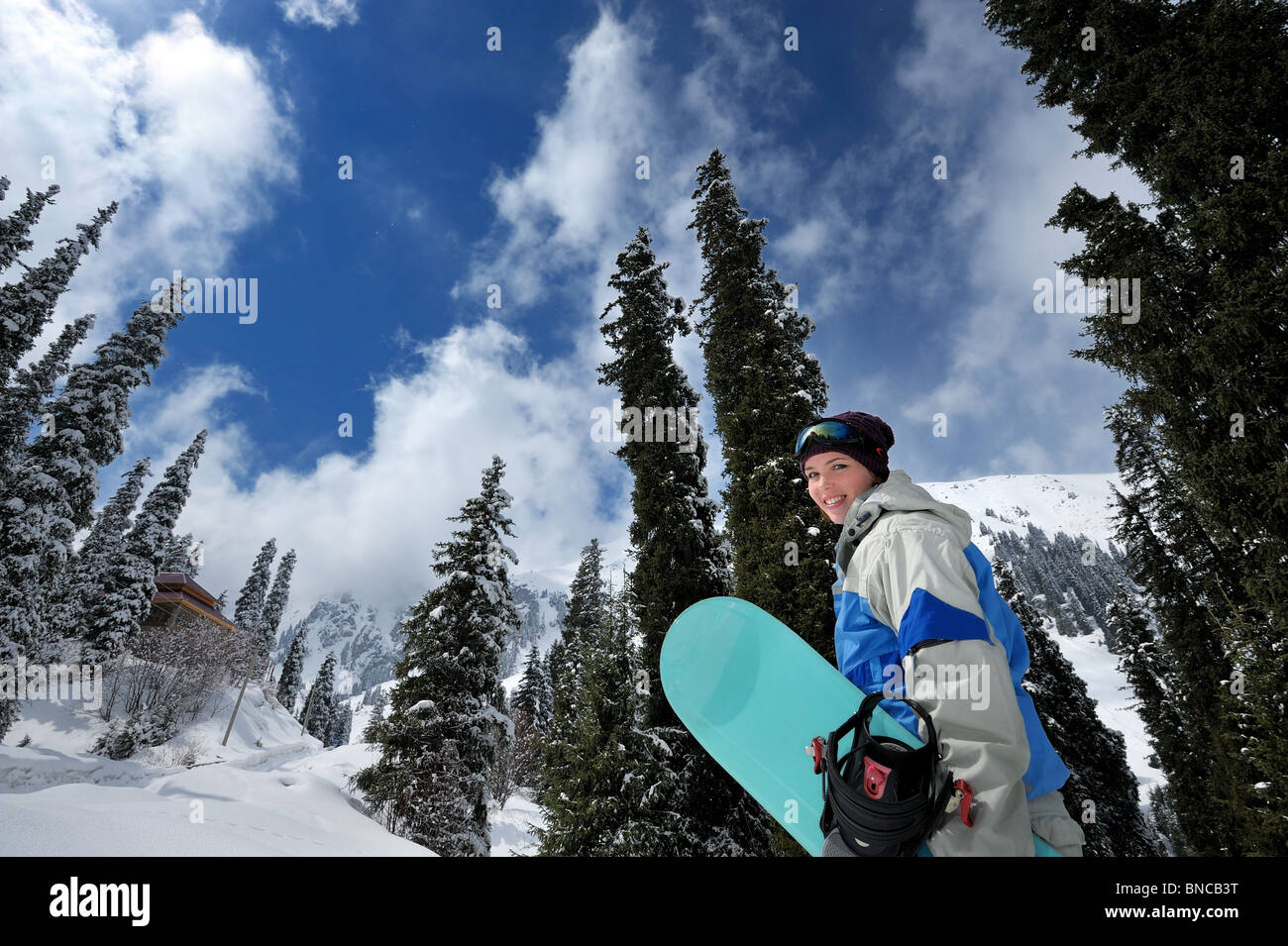 Pretty girl with snowboard smiling Stock Photo - Alamy