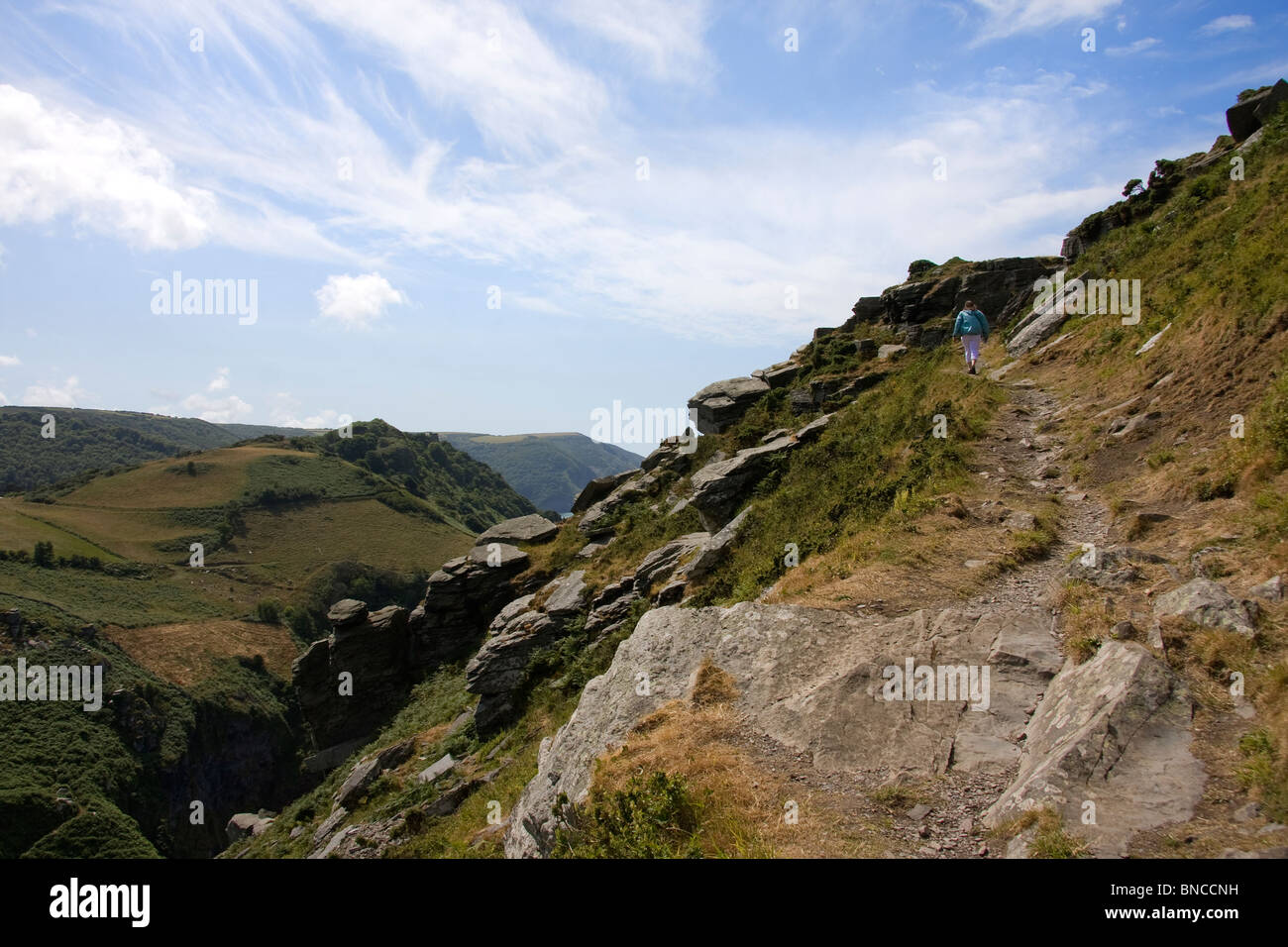 A person walking up Castle rock in the valley of the rocks near Lynton ...