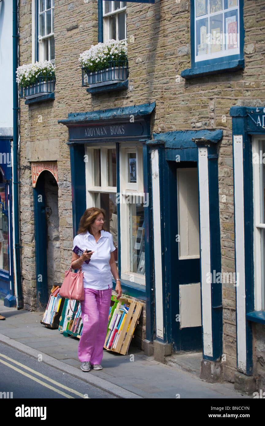 Woman walking past Addyman Books bookshop in booktown of Hay-on-Wye ...