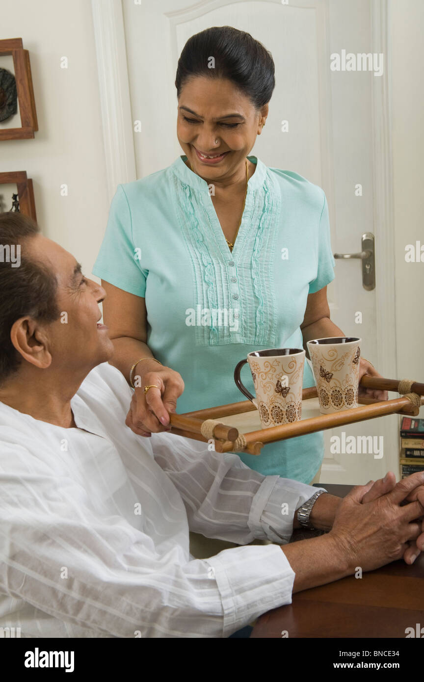 Woman bringing tea for a man Stock Photo - Alamy